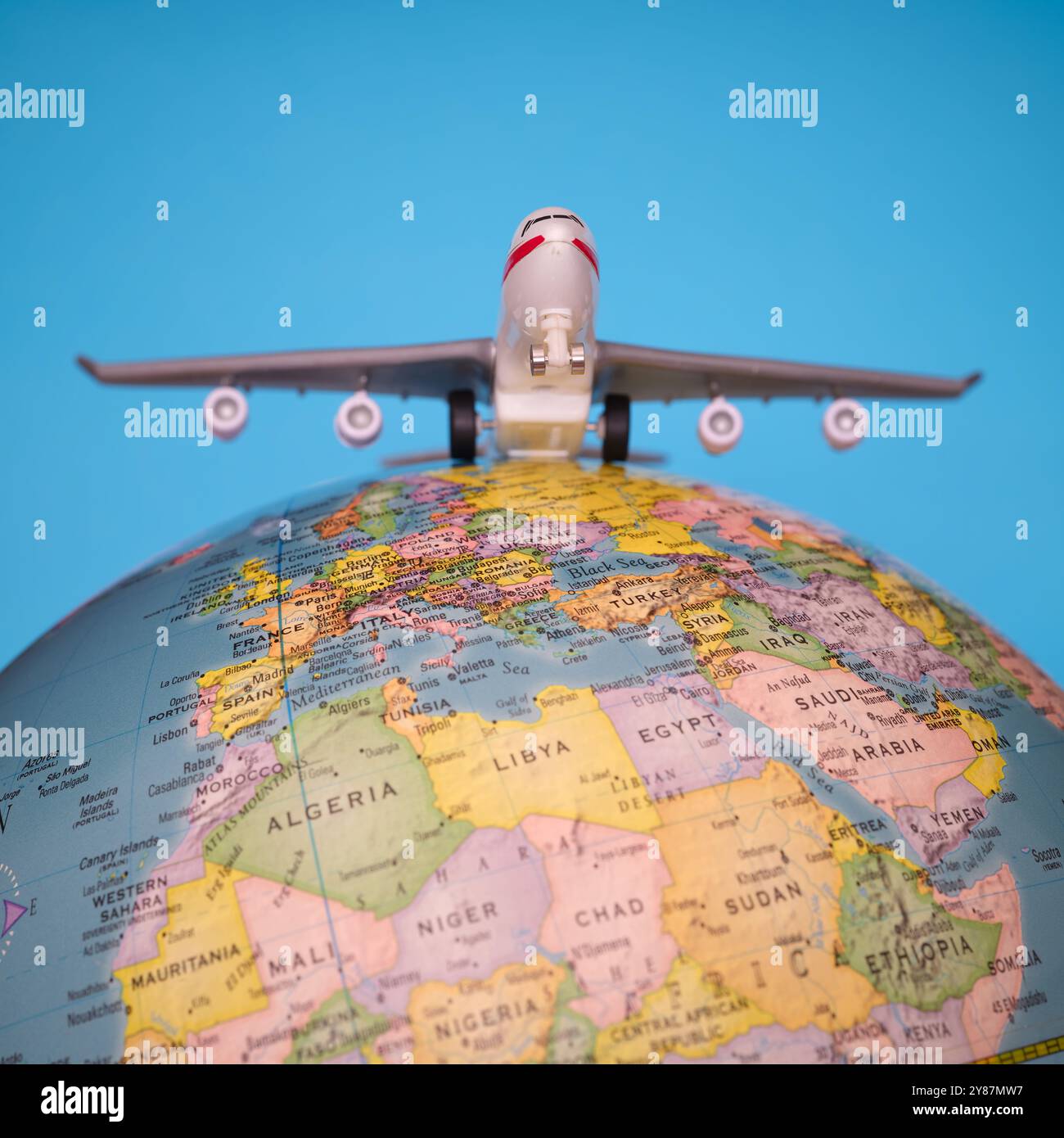 Airplane on a globe against a blue background. Flight around the world ...