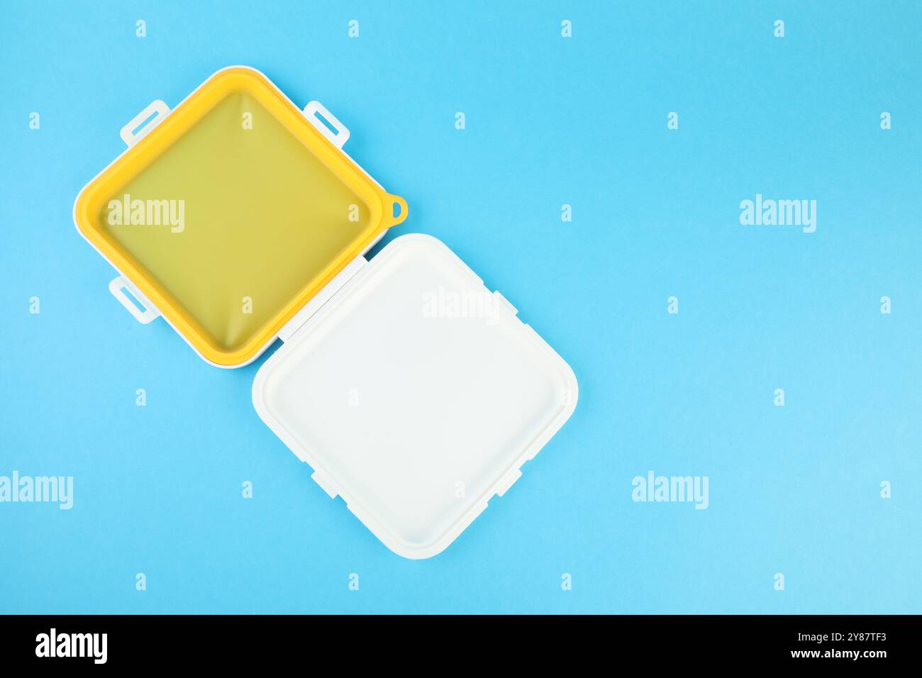 Empty sandwich lunch box on light blue background, top view. Space for ...