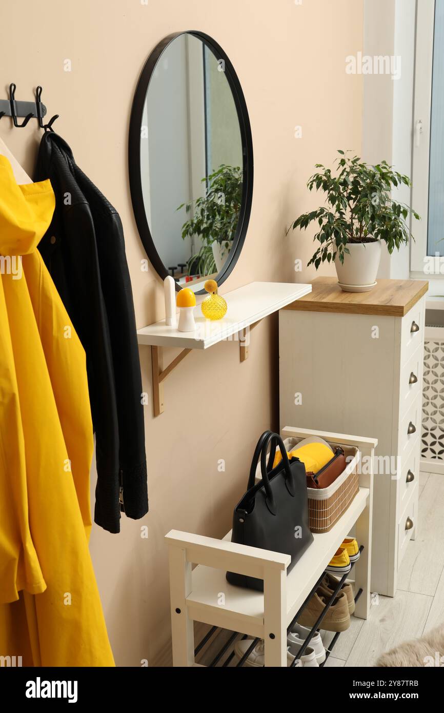 Coat rack with clothes, mirror, shoe storage bench and chest of drawers ...