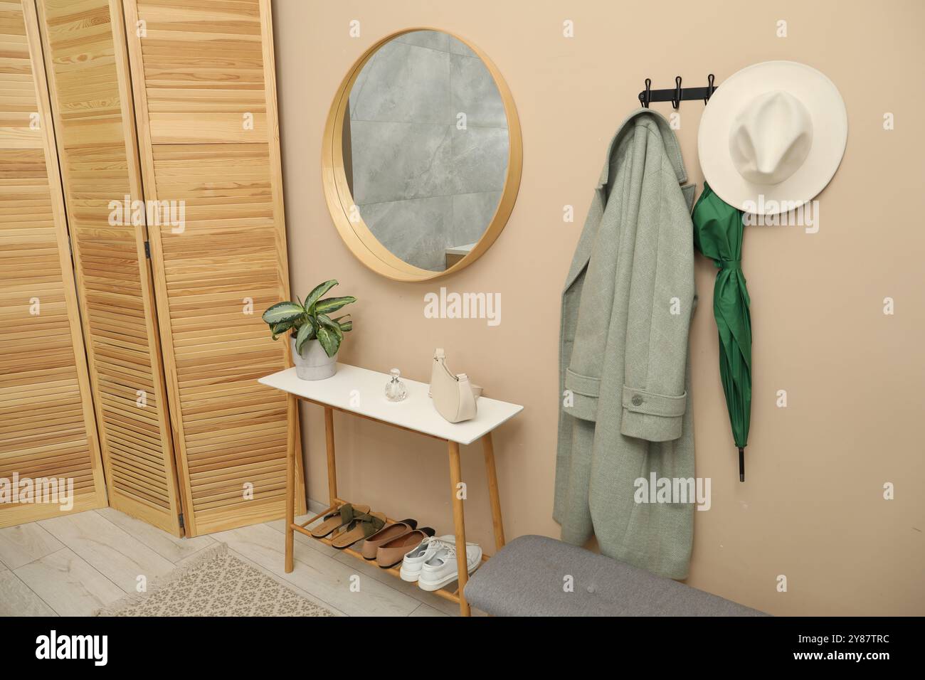 Coat rack with clothes, mirror, shoe storage benches and folding screen ...