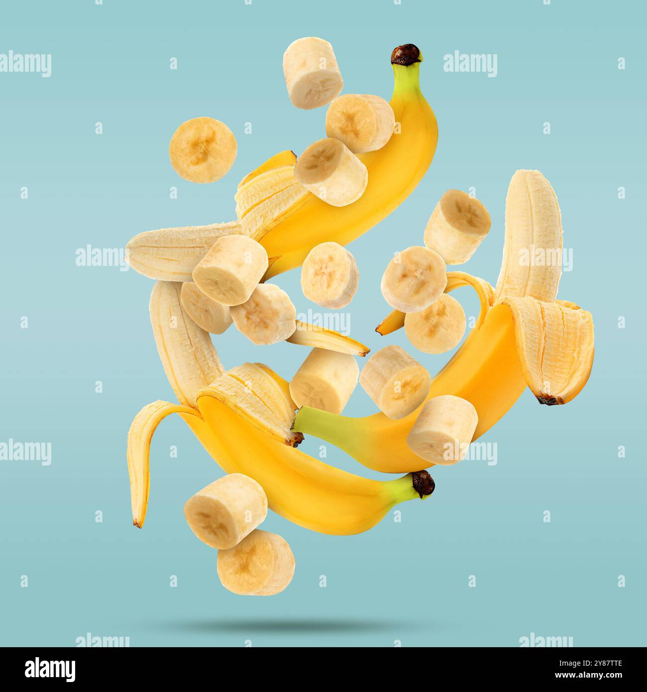 Fresh ripe bananas falling on light blue background Stock Photo - Alamy