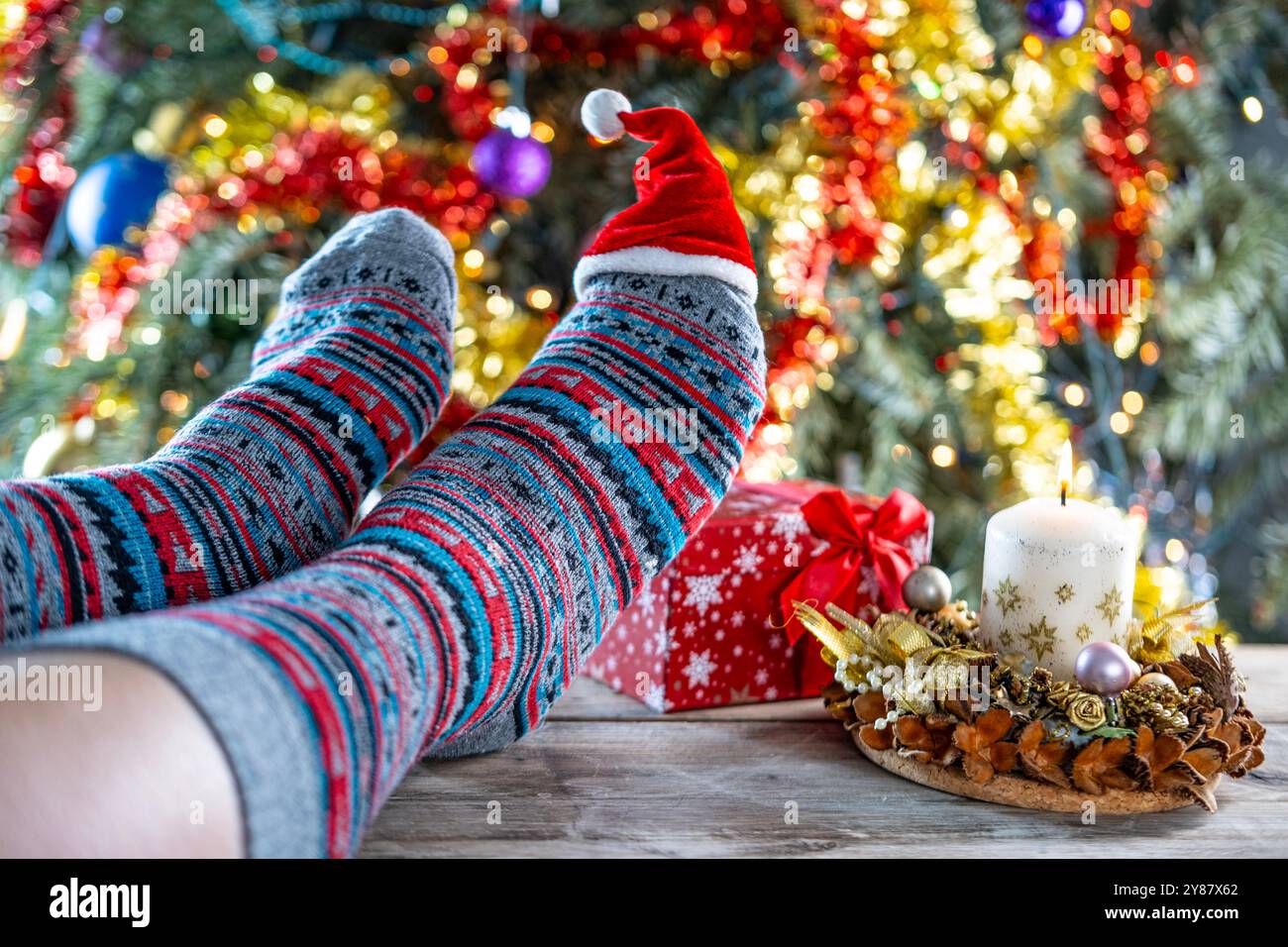 cozy winter scene with pair feet wearing Christmas socks with Santa hat ...