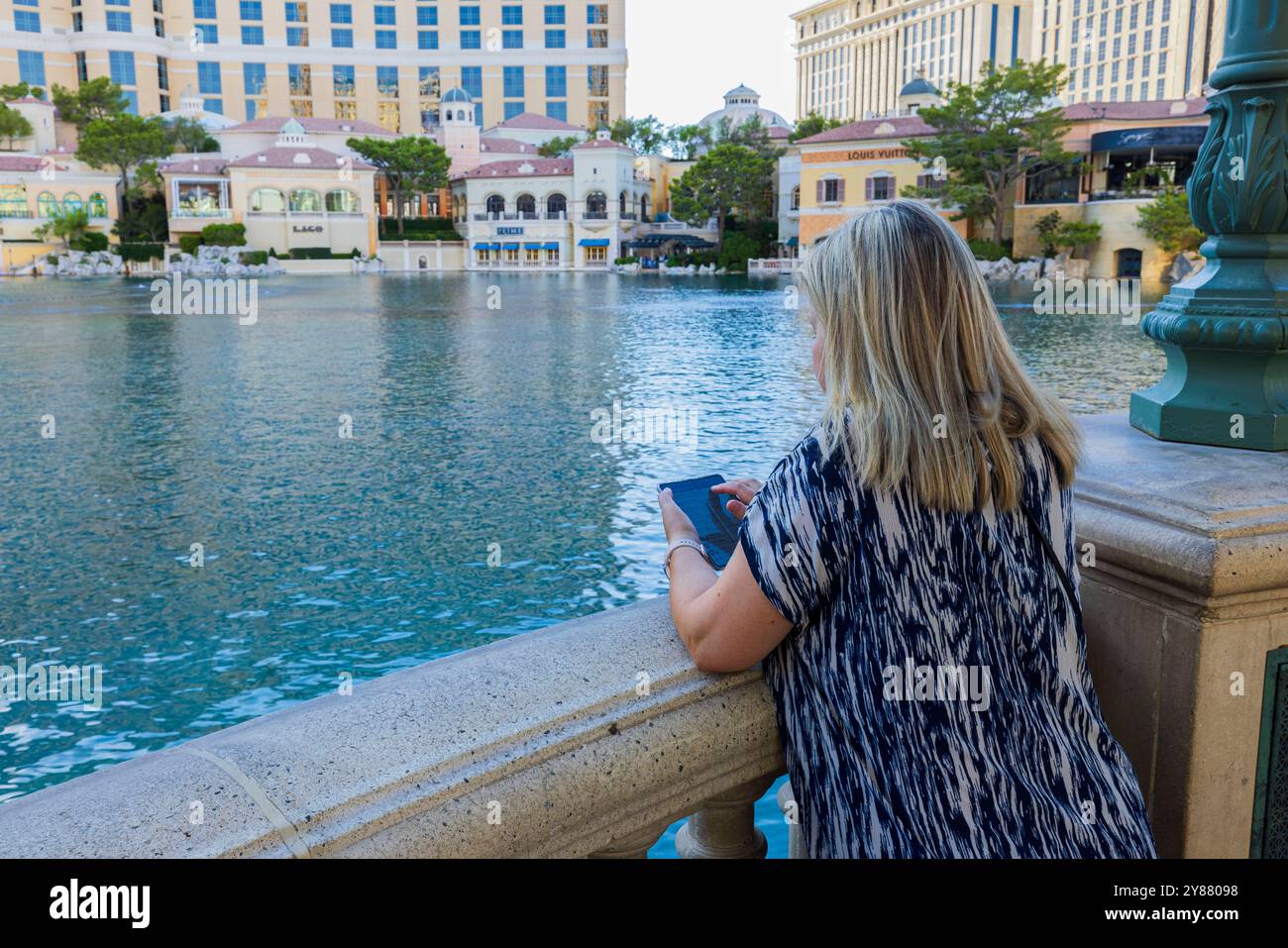 Woman using a smartphone by Bellagio fountain at Las Vegas Strip in ...