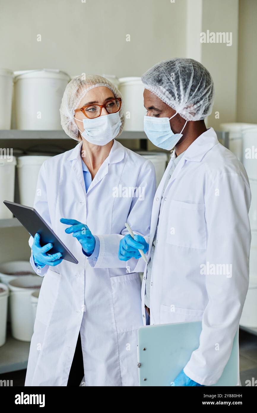 Vertical shot of female process technician using digital tablet while ...