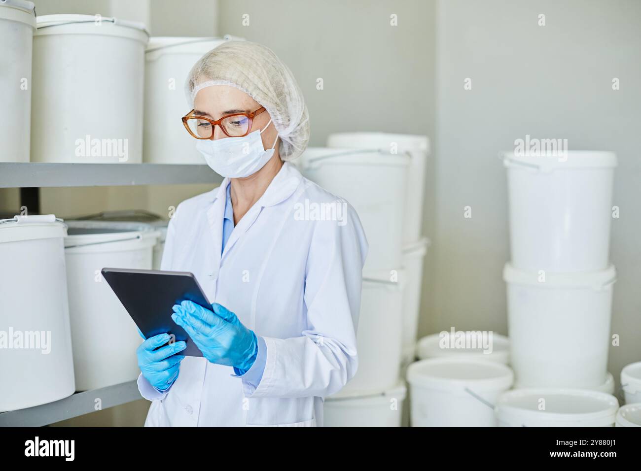 Medium shot of concentrated female process technician using digital ...