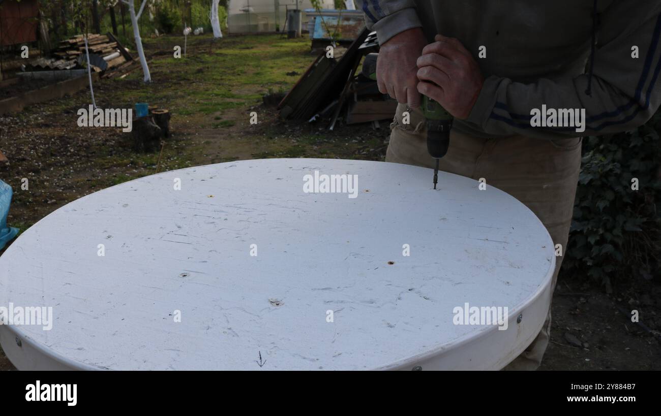 the hands of an assembler with a screwdriver during the assembly of a ...