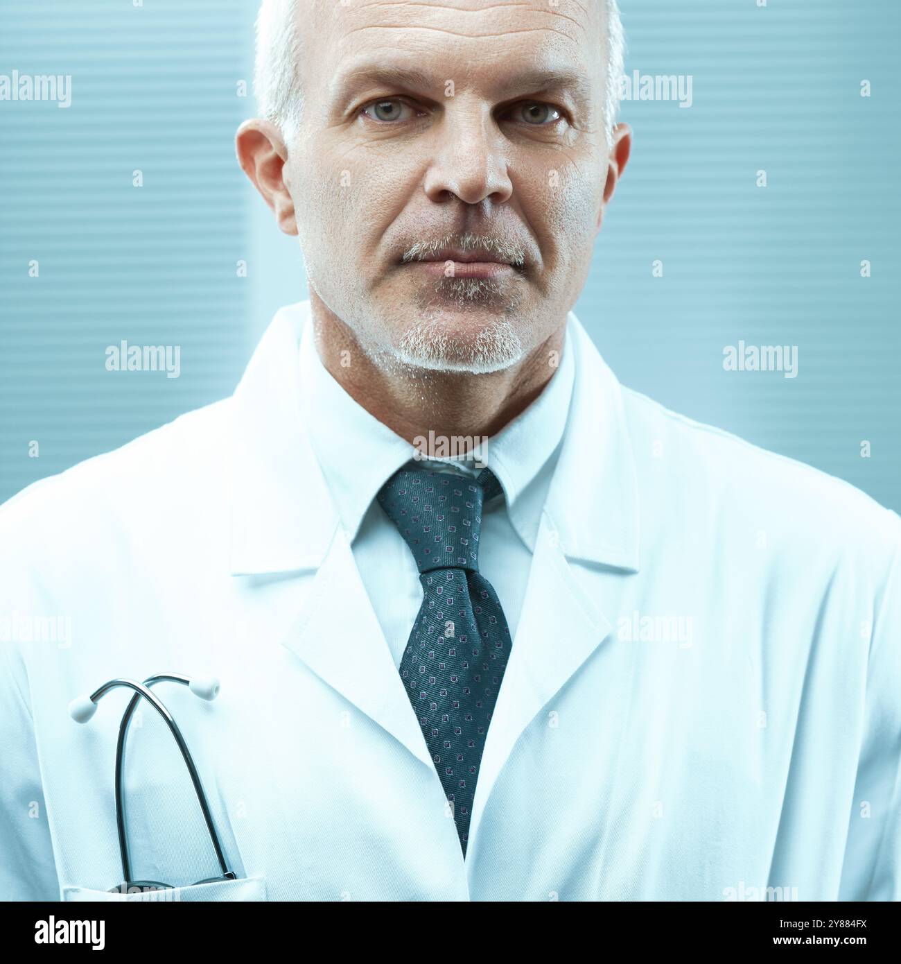 Mature medical professional with a serious expression is posing in a ...