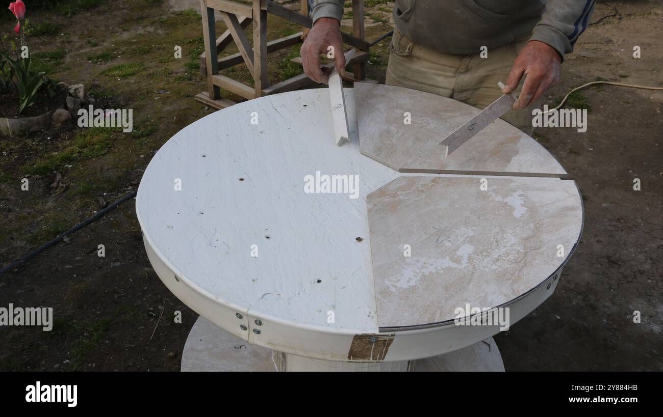 the creator lays out and measures the location of decorative tiles on a ...