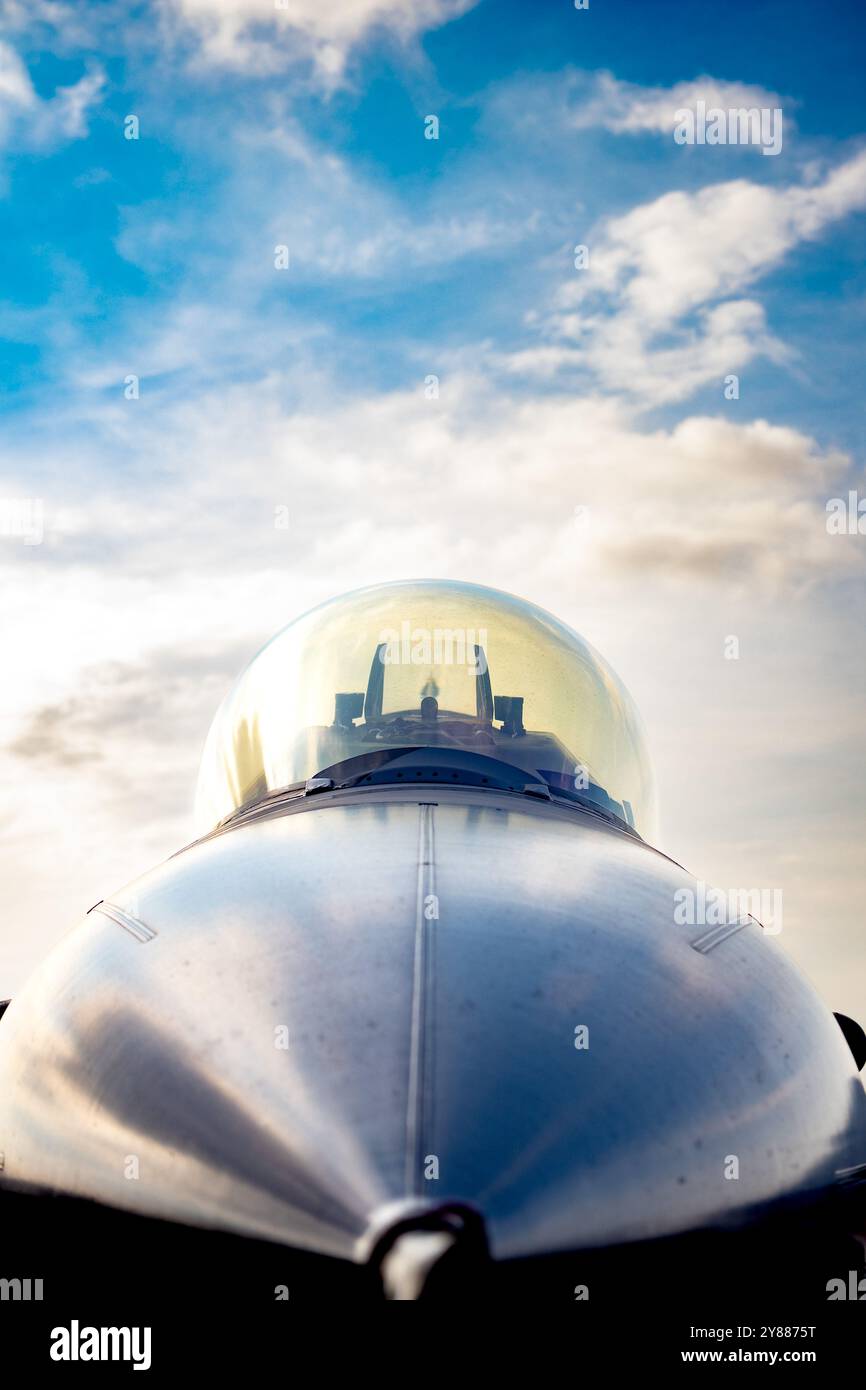 Front close-up of jet fighter plane in parking lot. Airplane on blue ...