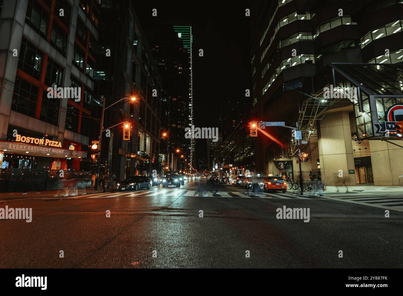 Long exposure of pedestrians crossing zebra crossing at night in ...
