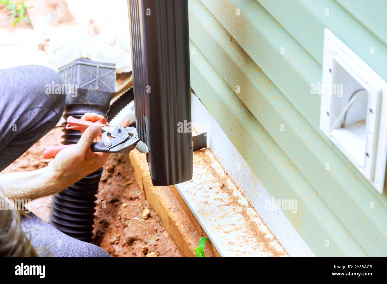 This handyman is assembling gutter channels that have been attached to ...