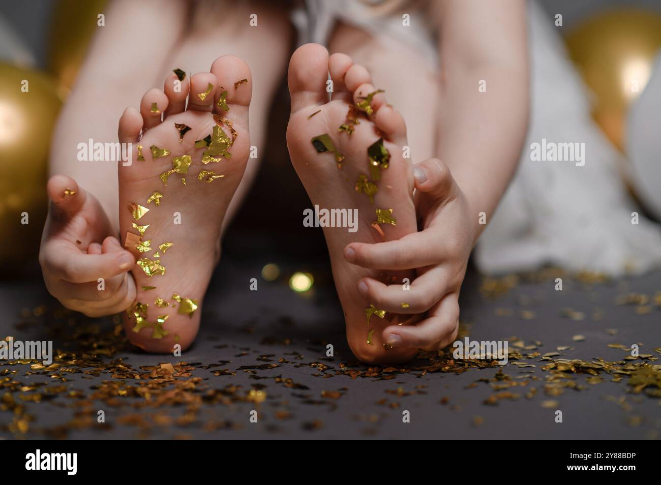 golden confetti on the girl's feet. birthday celebration Stock Photo ...