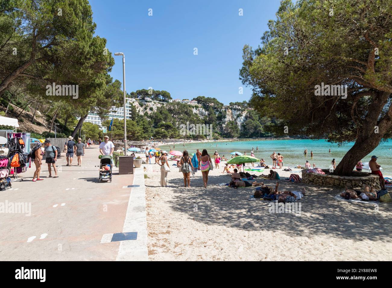 People walk on the beach of Cala Galdana on the Spanish island of ...