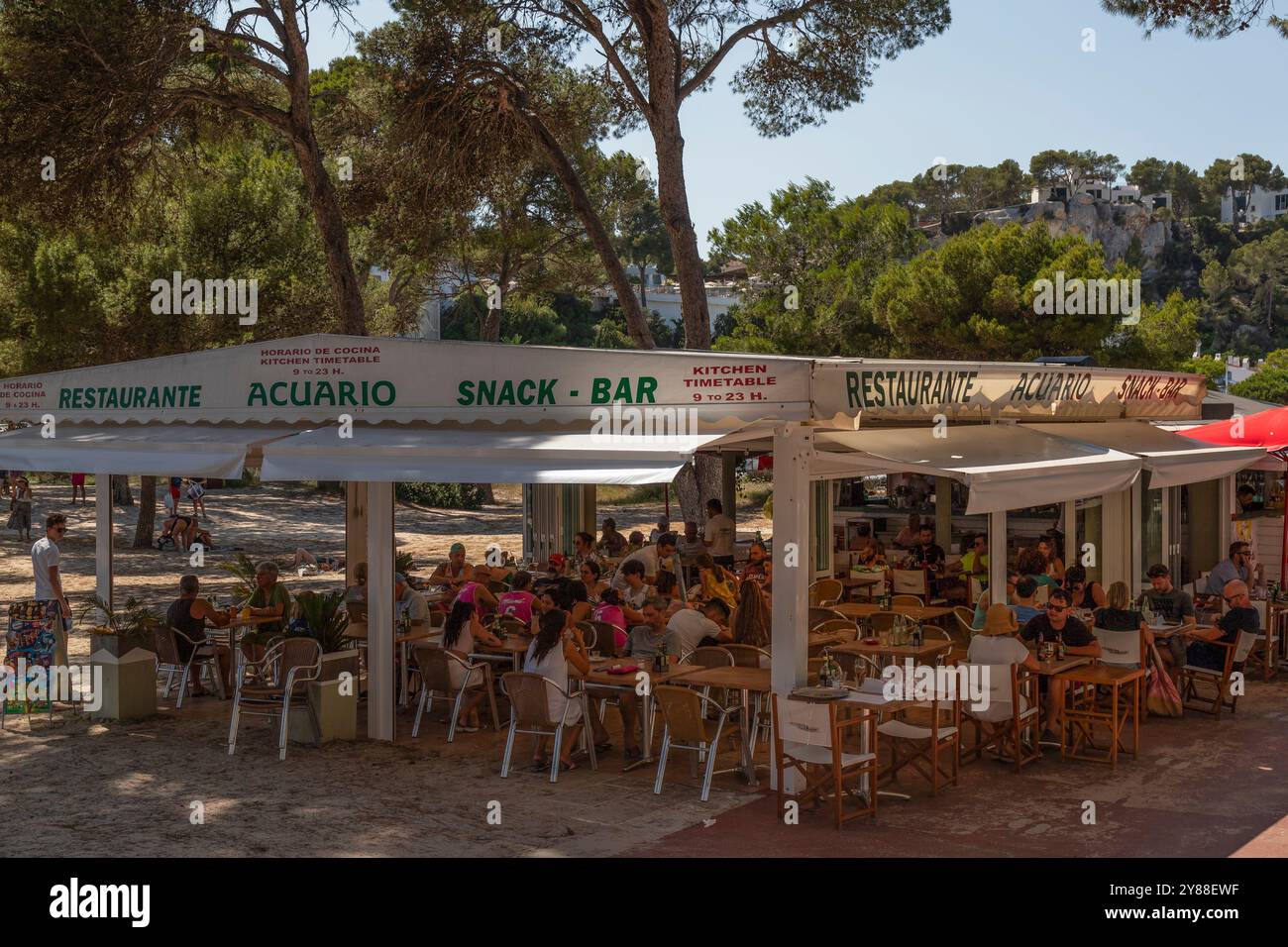 People enjoy a restaurant on the beach of the seaside resort of Cala ...