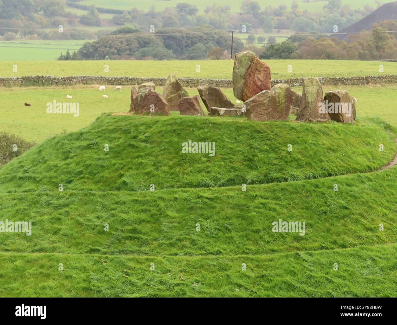Huge boulders atop one of the mounds with a spiralling path ...