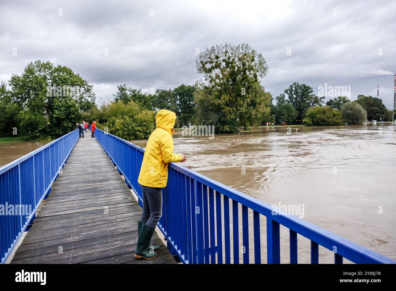 Worried people looking from bridge at flooded river. Extreme weather ...