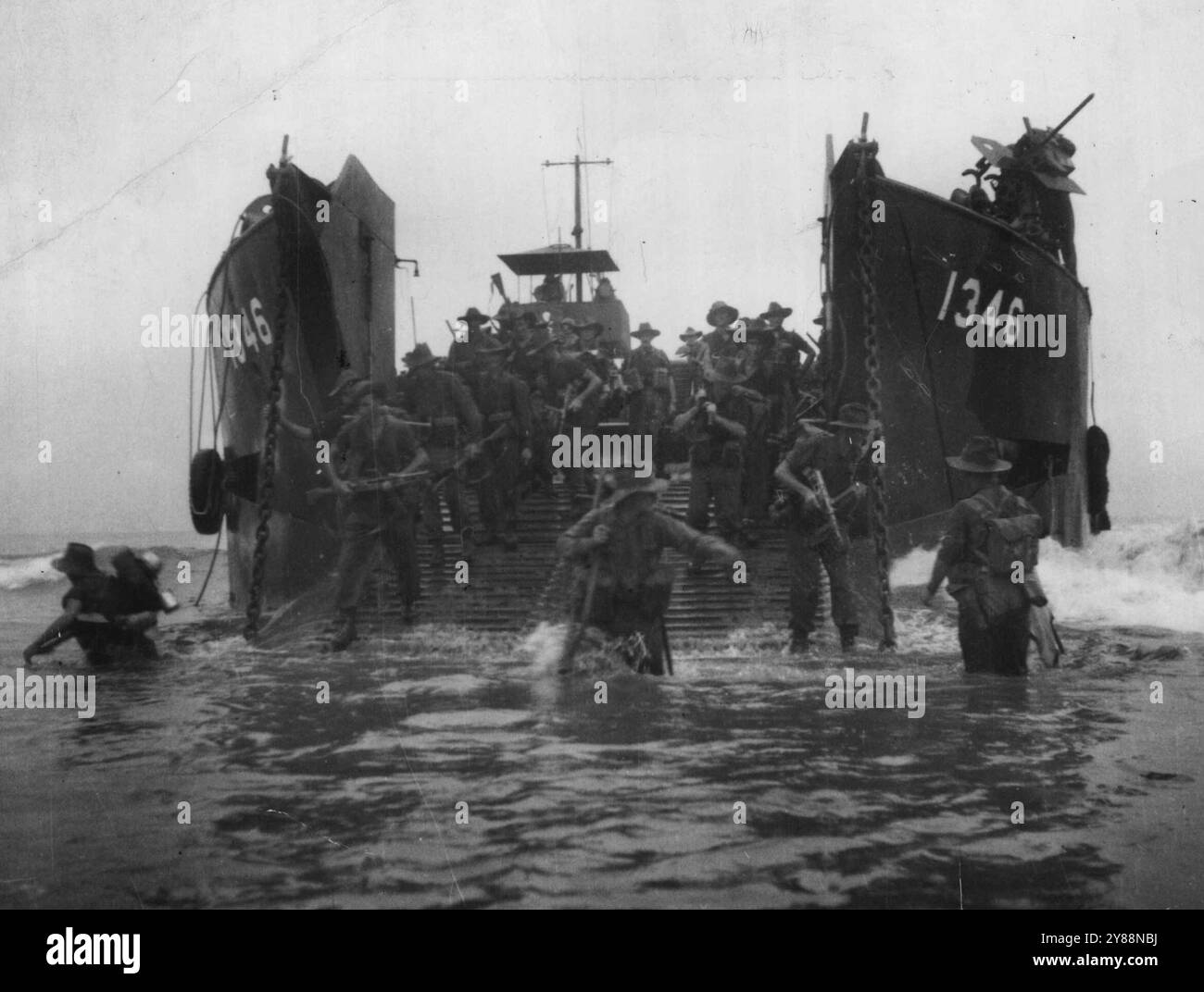 Members of the 6th Australian Division stream from the landing craft on ...