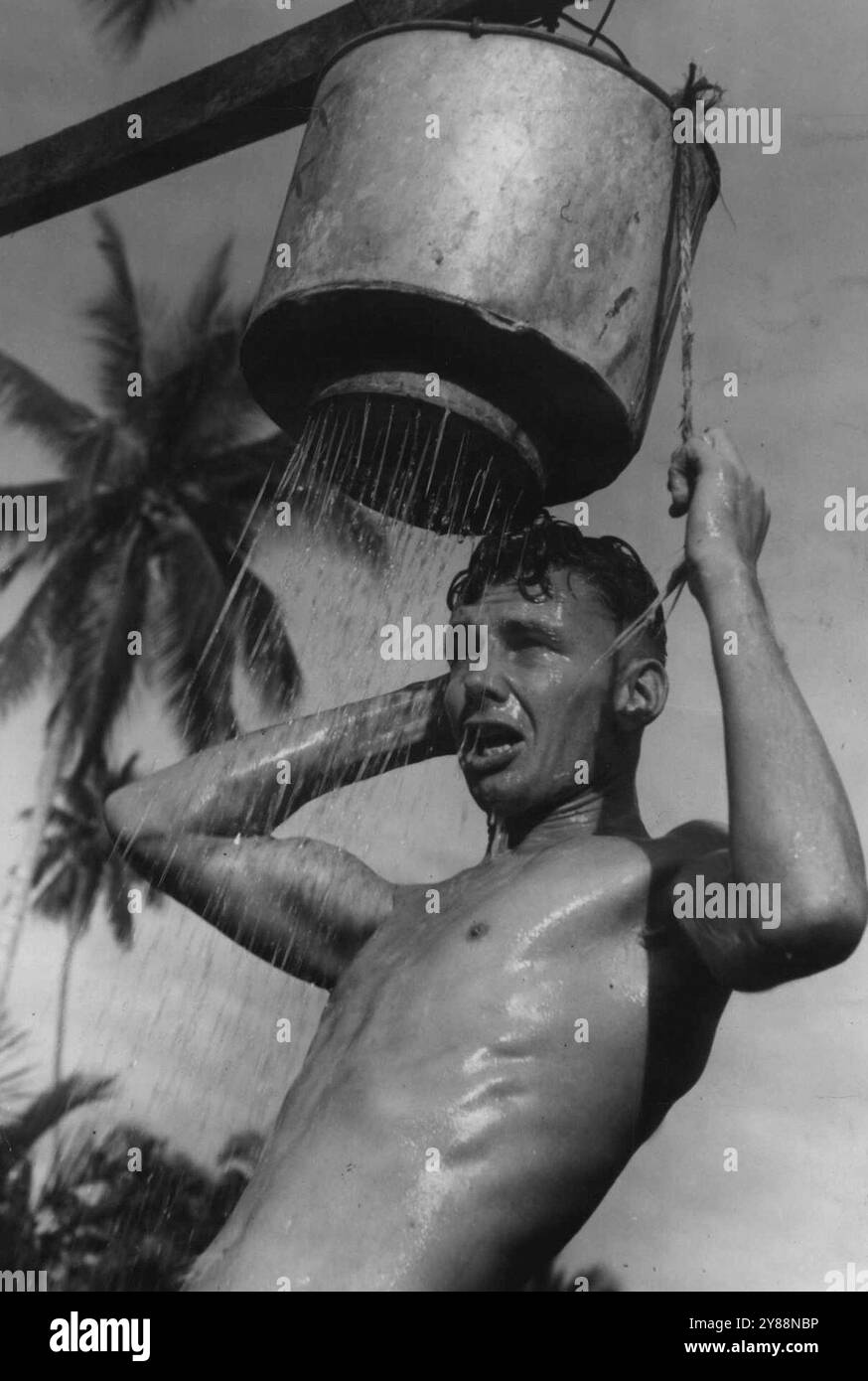 Open air shower in an Australian Army camp in Dutch New Guinea. Sergt ...