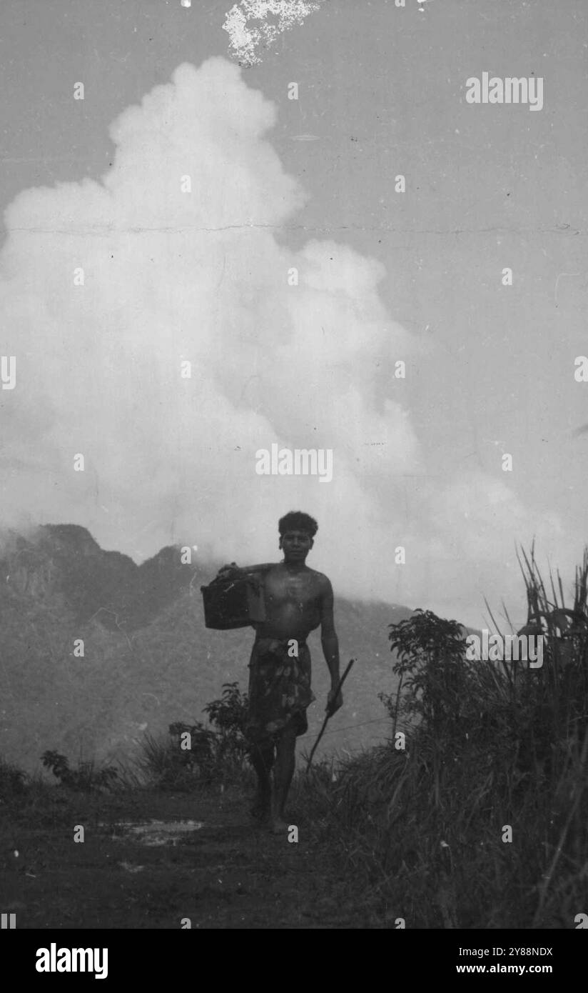 A native carrier reaches the top of a hill after a long and arduous ...