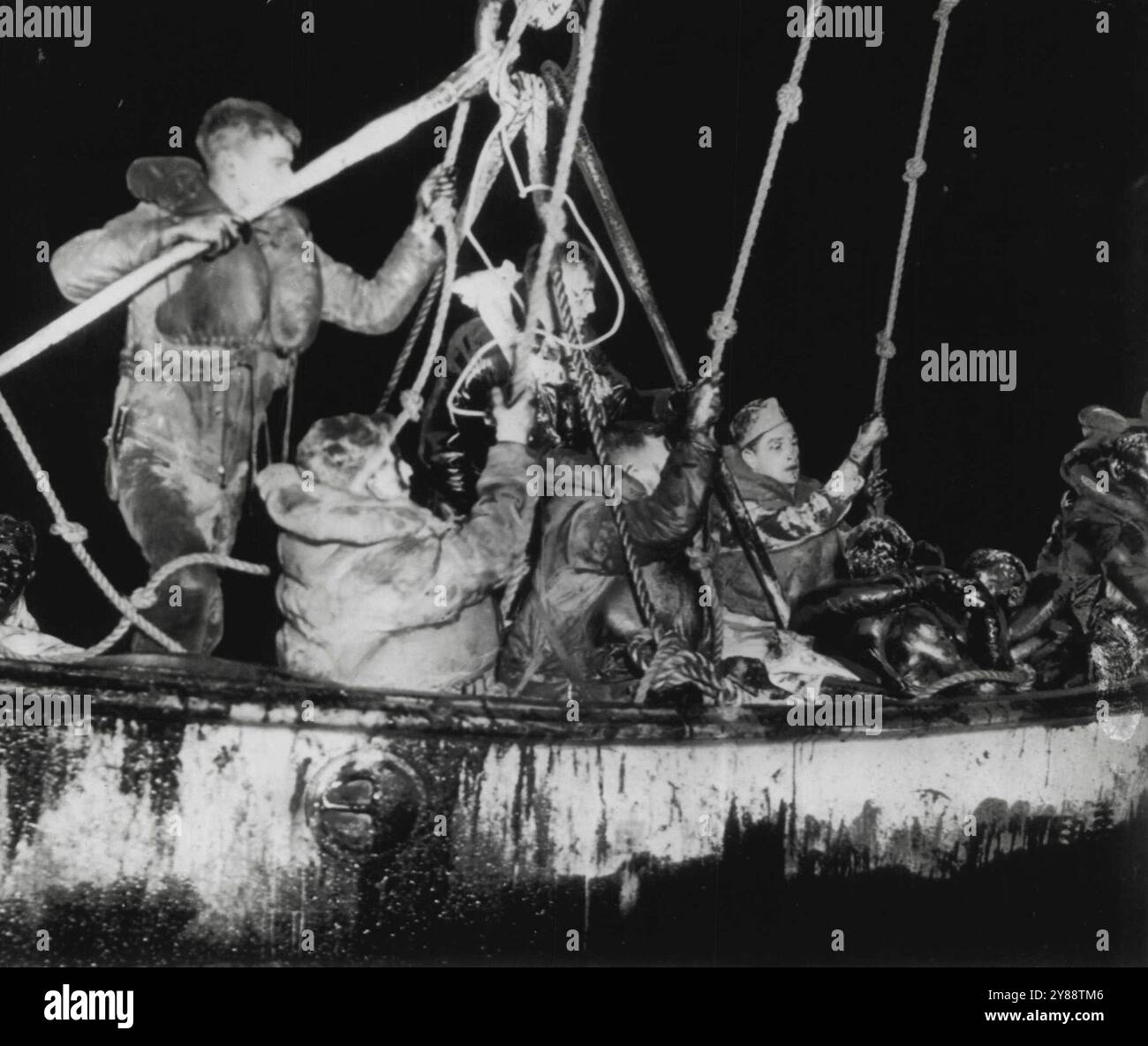 Lifeboat Hoisted Aboard Wasp - A lifeboat with three oil-covered ...