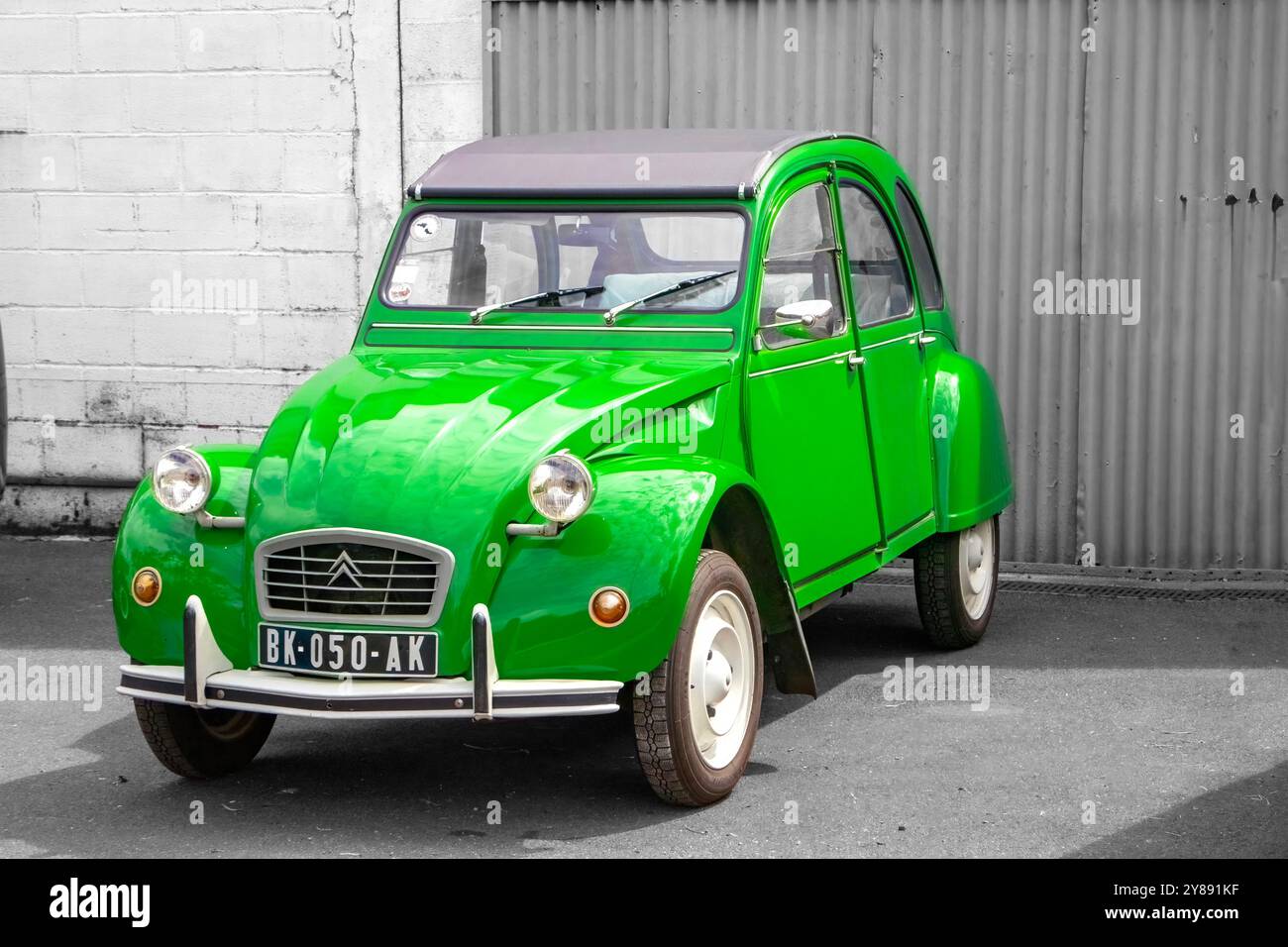 bright green classic vintage citroen 2cv or deux chevaux parked outside a french garage france ...