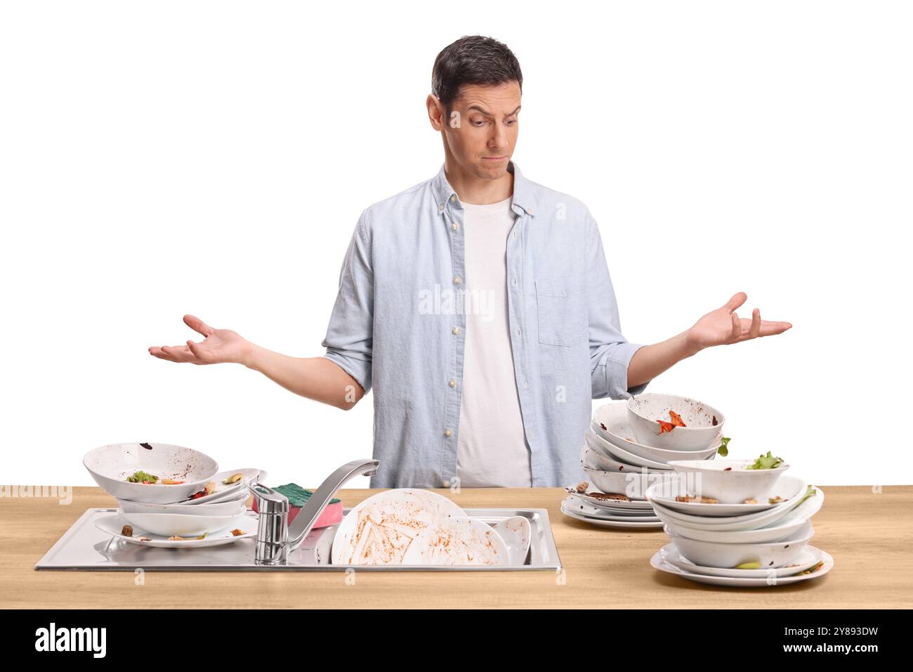Angry man with a pile of dirty dishes in a kitchen sink on a wooden ...
