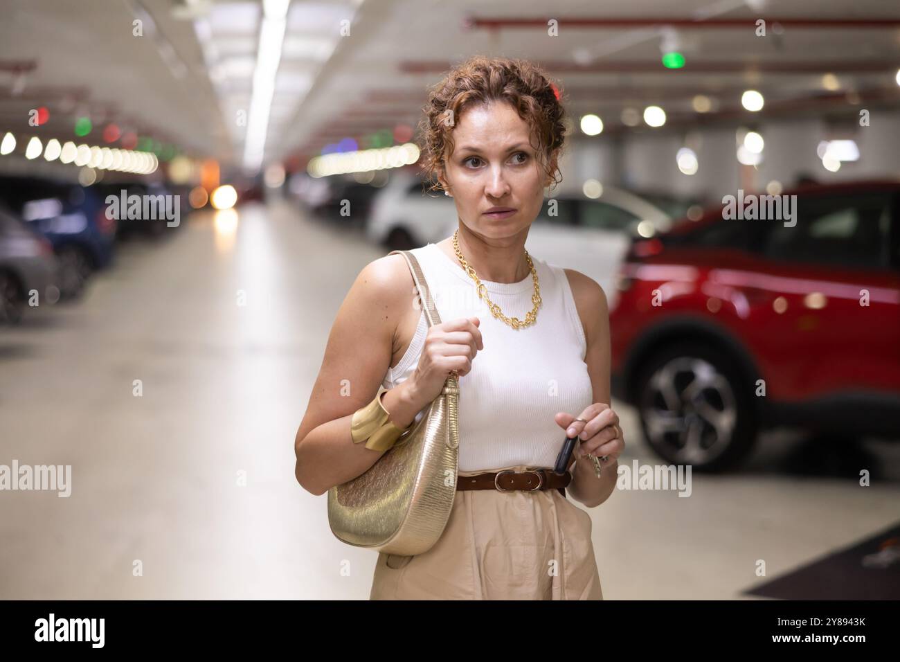 Adult woman stands in parking lot with keys Stock Photo - Alamy