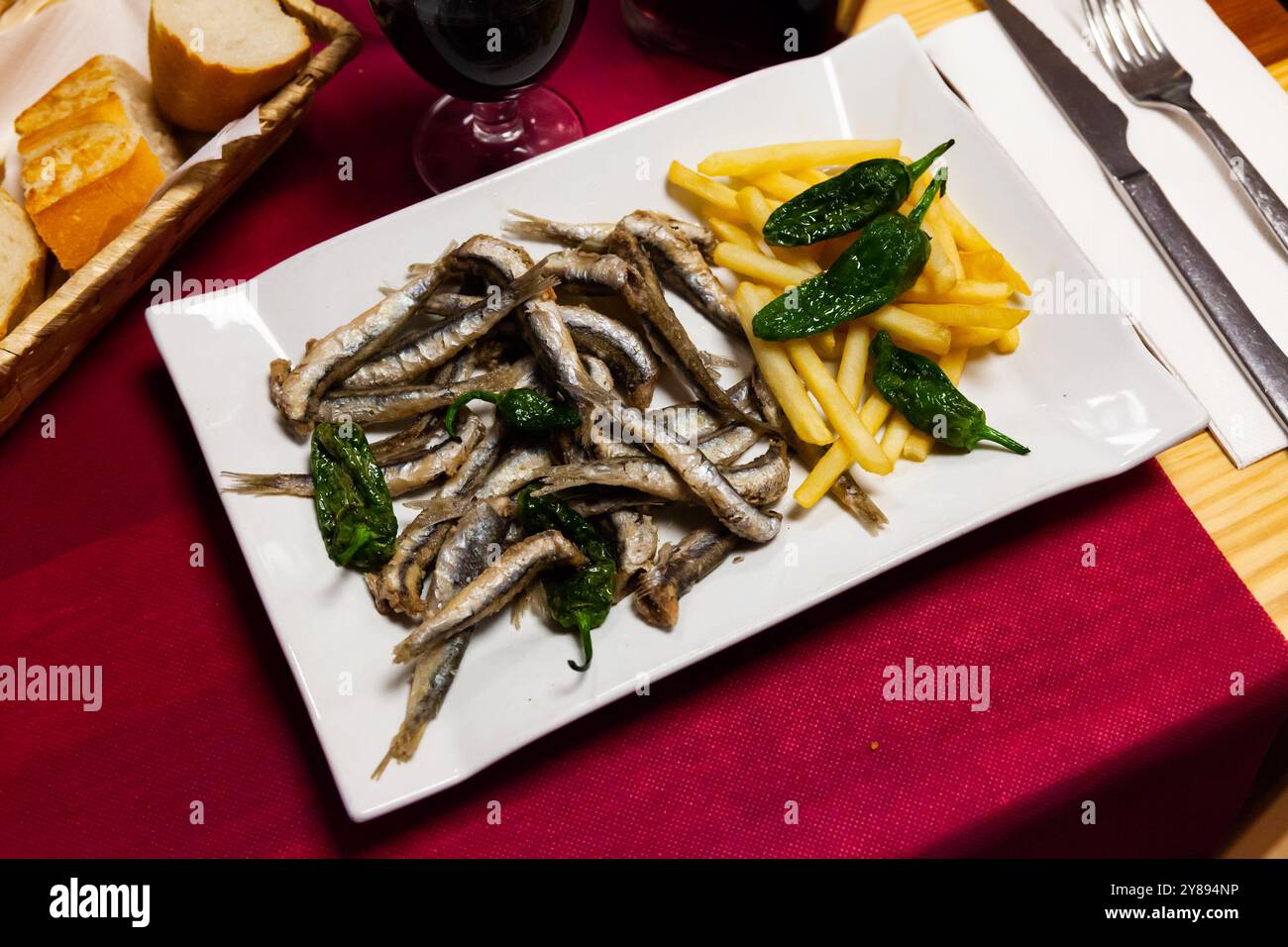 Delicious dish of fried anchovy with french fries and green pepper ...