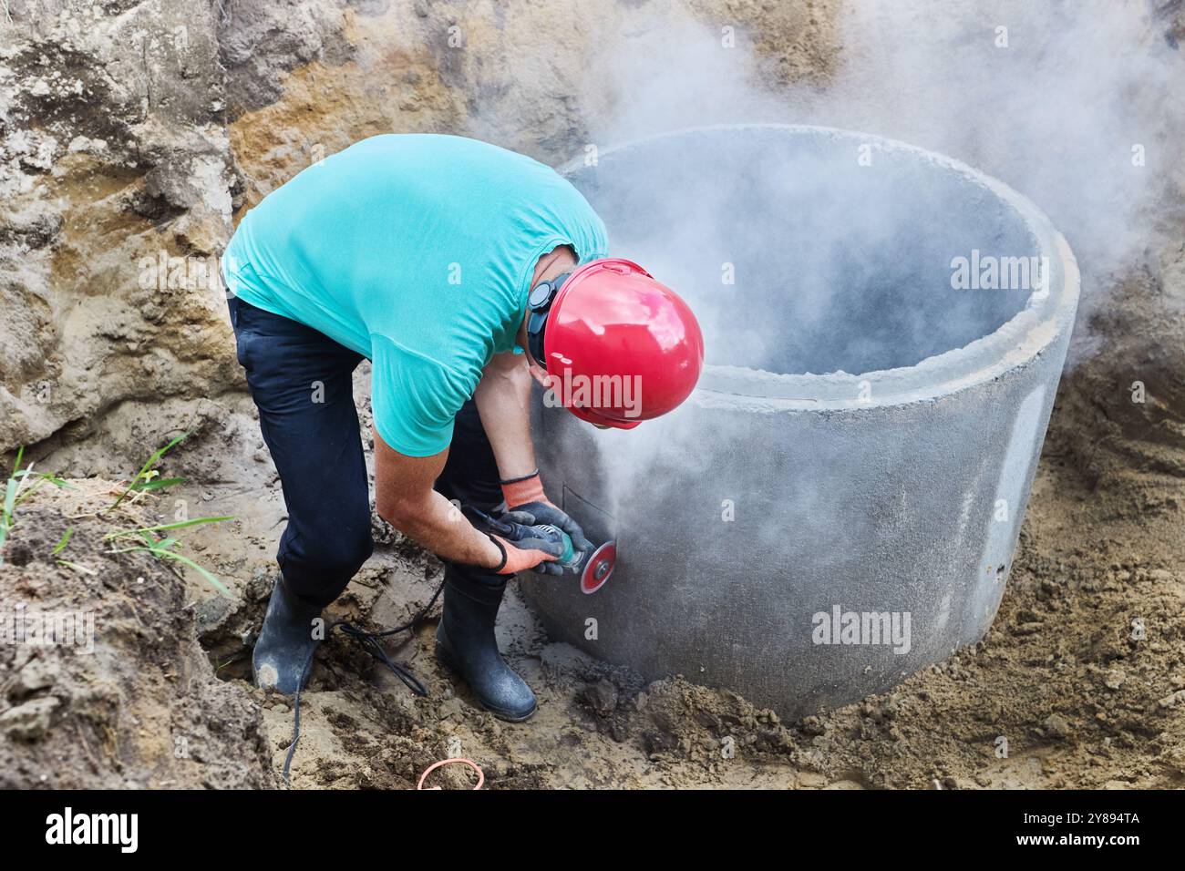 Cutting concrete with diamond blade during installation of septic tank ...