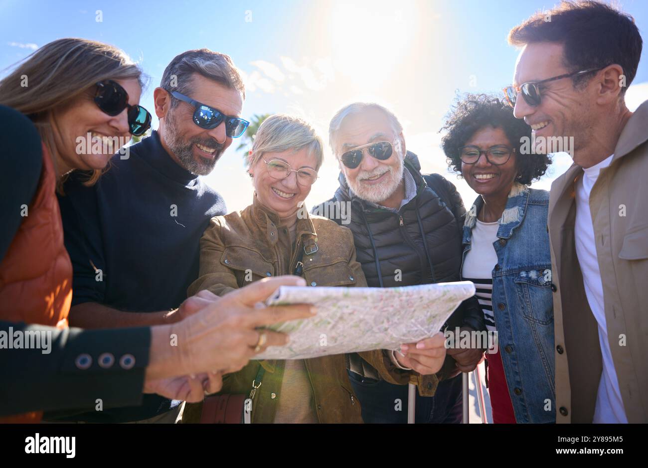 Group of diverse middle-aged tourist people standing looking at travel ...