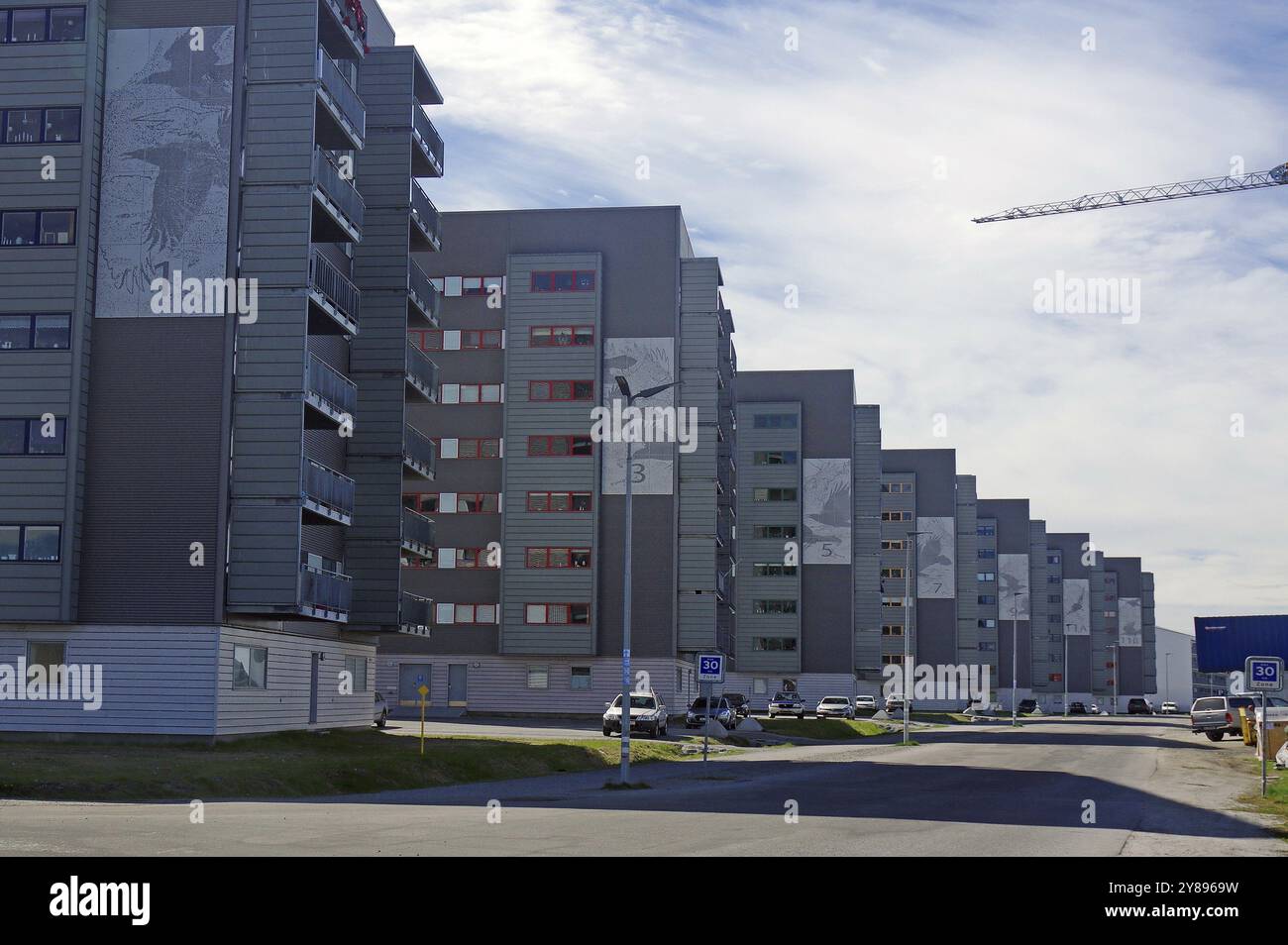 Modern flat blocks line a quiet street under a cloudy sky, Nuuk ...