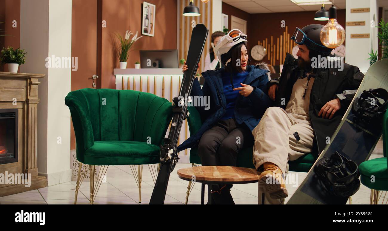 People sitting in lounge area with sliding gear, preparing to go skiing ...