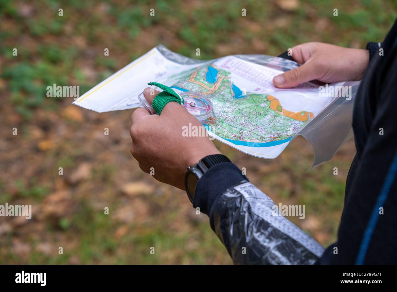 Man holding a map and the compass during orienteering competitions ...