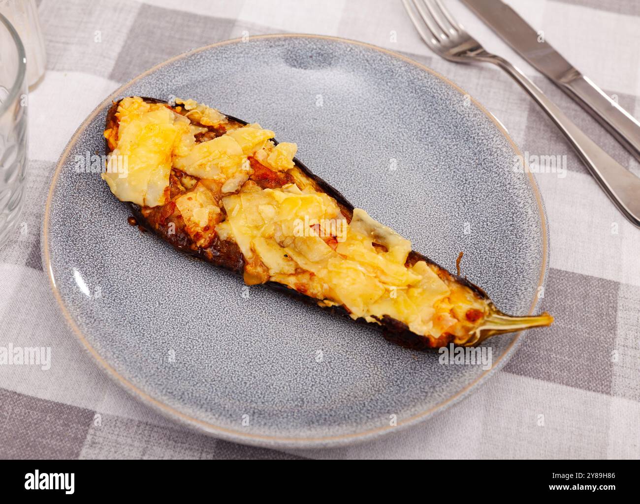 Baked half of eggplant gratinated with cheese Stock Photo - Alamy