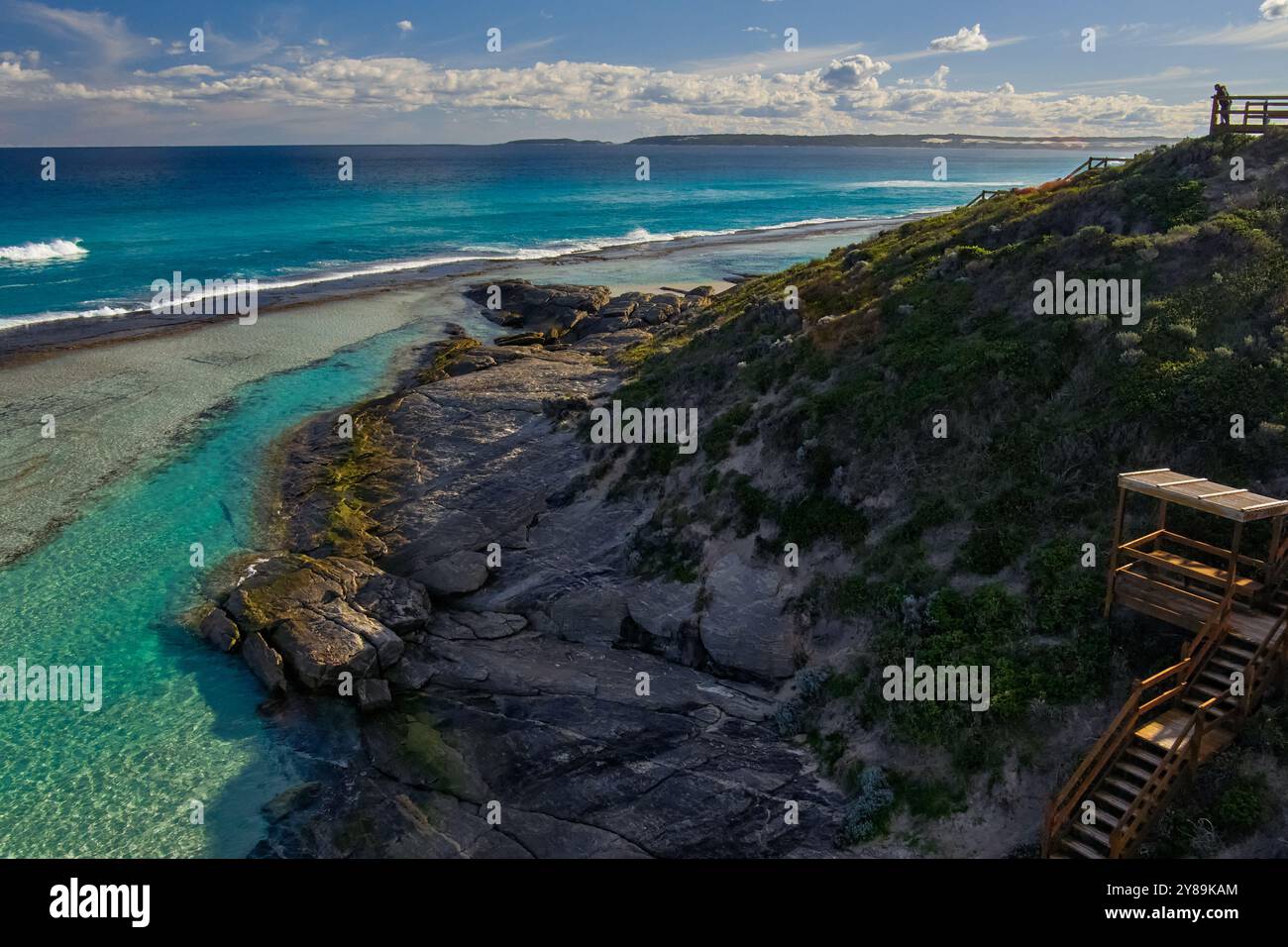 stairs lead to a viewing platform above sand dunes and rugged coastline ...