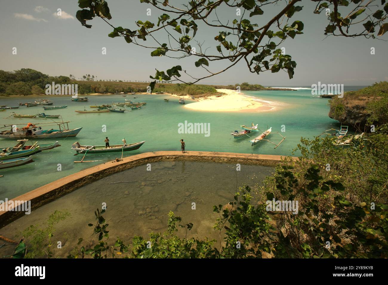 A fisherman standing on a concrete pathway on the fishing beach of Pero ...