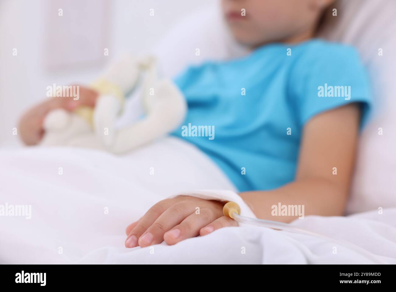 Little girl with IV drip on bed in hospital, closeup Stock Photo - Alamy