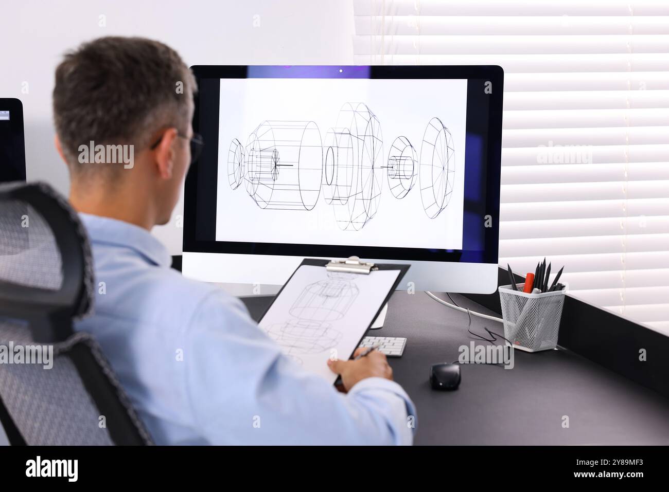 Architect checking engineering drawing at table in office Stock Photo ...
