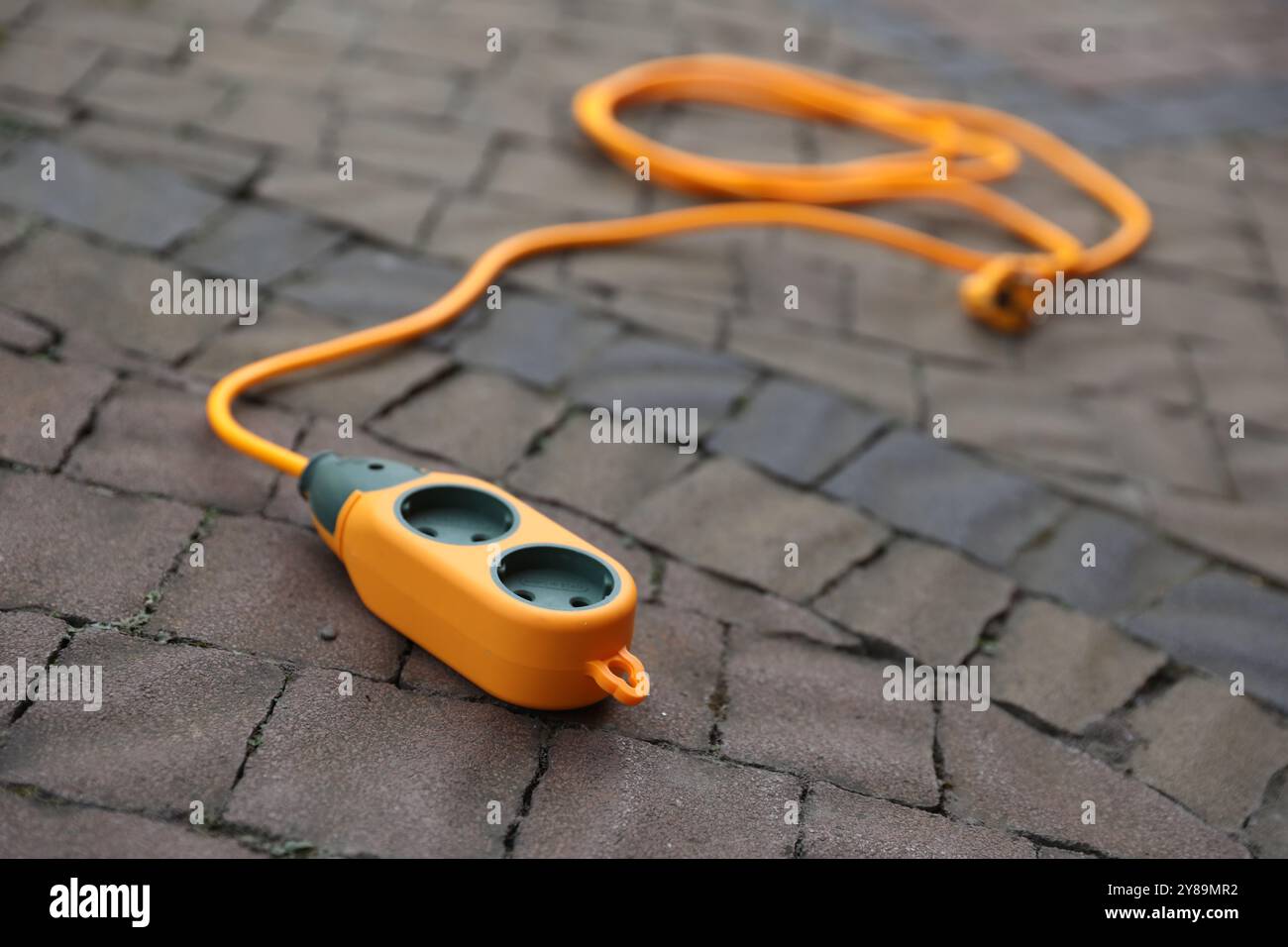 One extension cord on paved pathway outdoors Stock Photo - Alamy