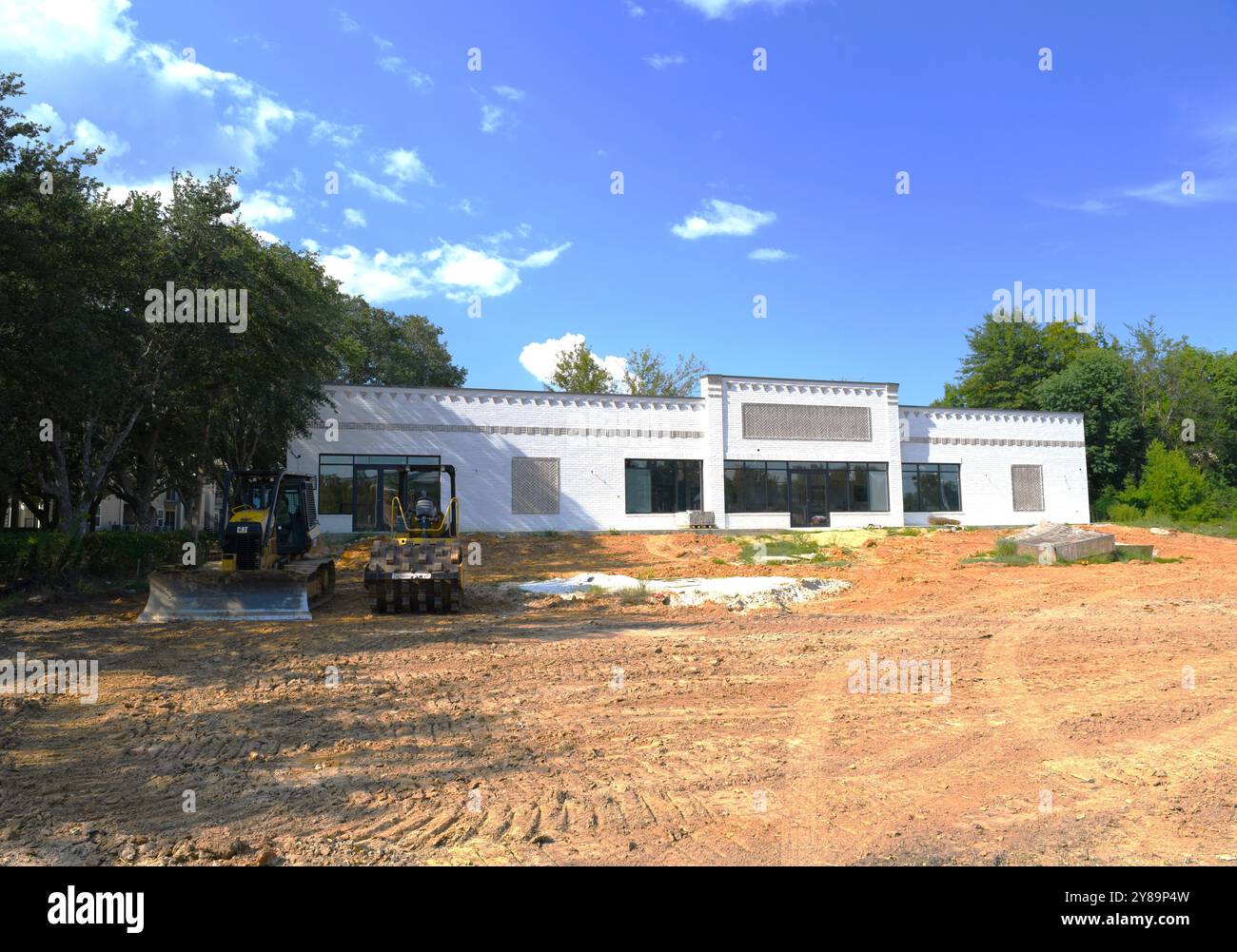 Storefront construction with bulldozer and compactor Stock Photo - Alamy