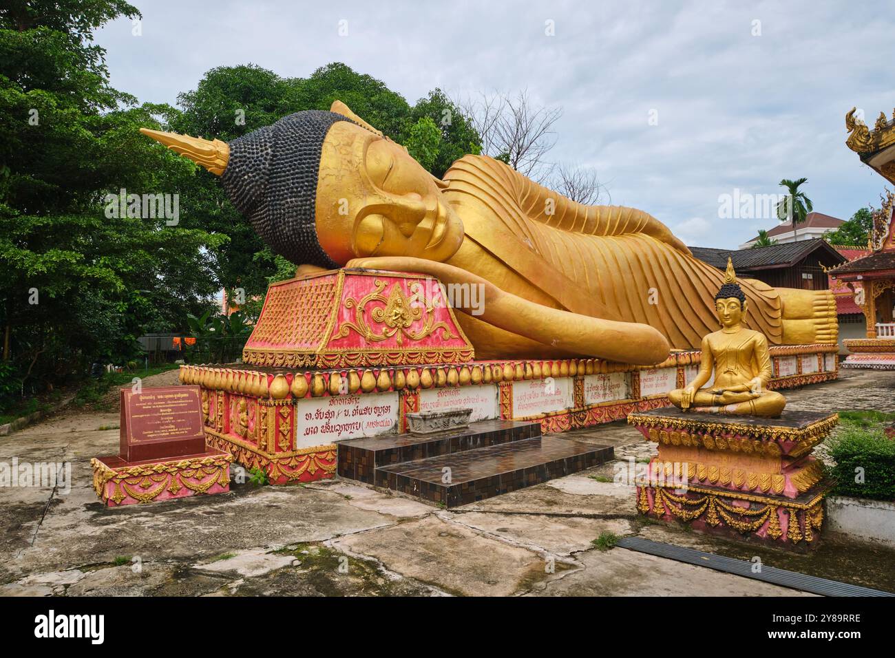 A large, exterior, painted, gold, reclining, relaxing, sleeping Buddha ...