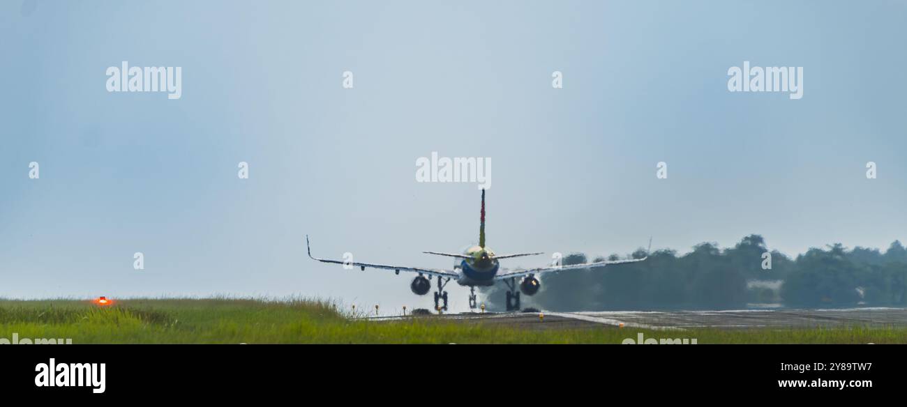 A passenger jet is taking off on the runway, with the jet engine ...