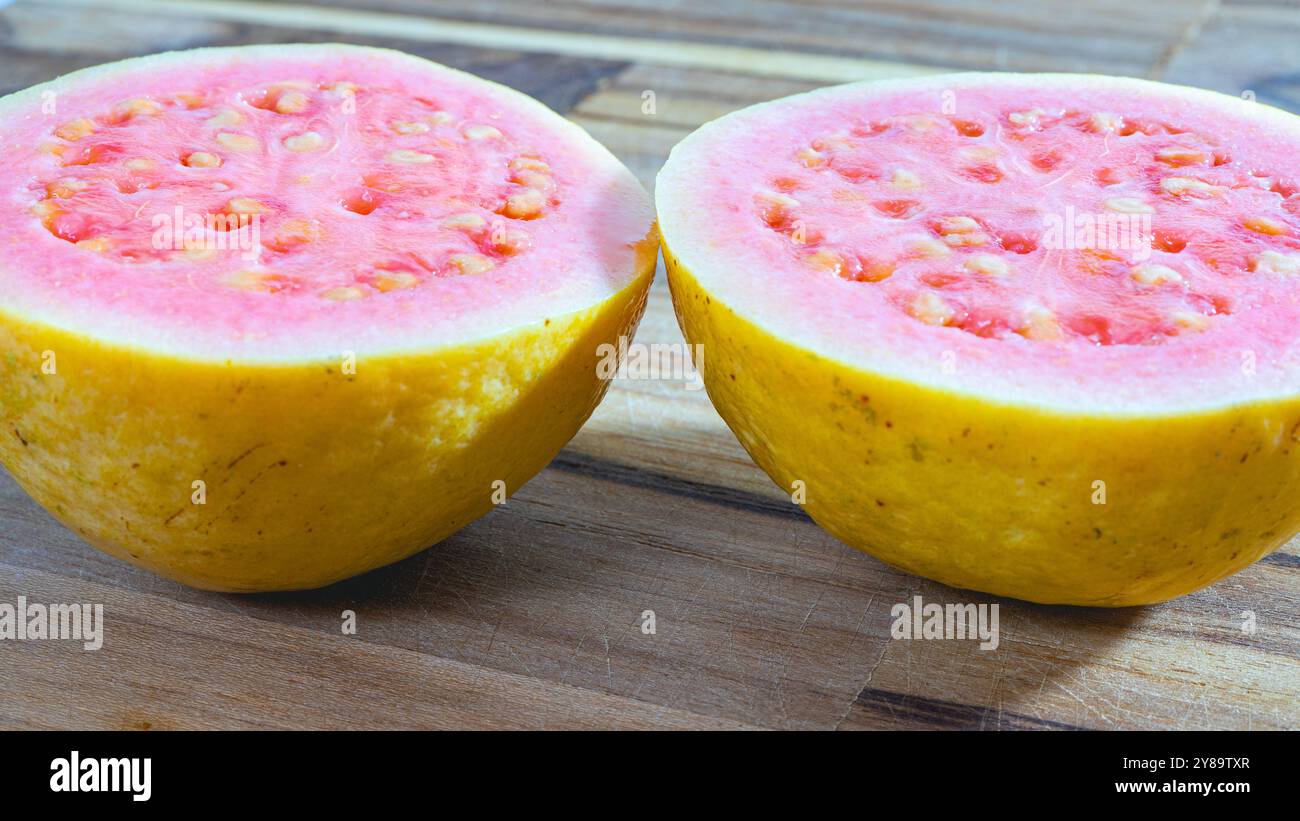 A Guava cut in half, On a wooden cutboard. Tropical Fruits Stock Photo ...
