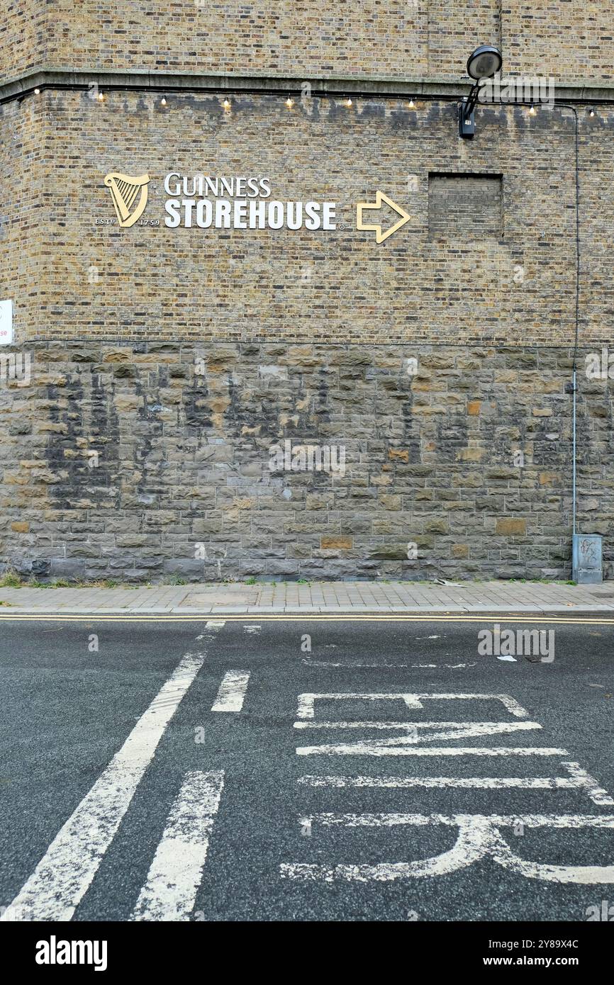 Sign on a brick wall at an intersection directing visitors, tourists ...