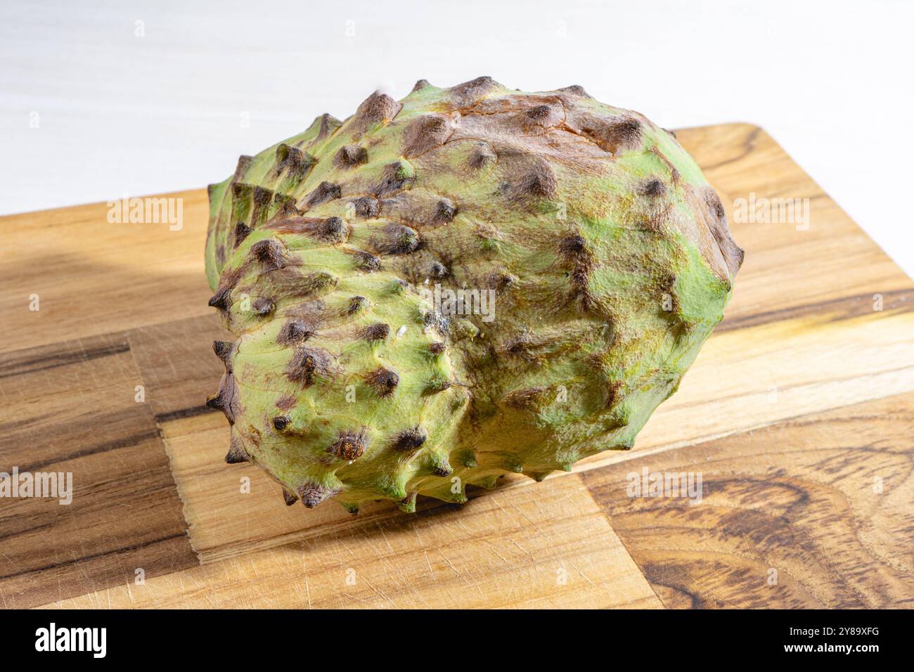 Atemoya, a tropical fuit, laying down on a wooden board, with a white ...