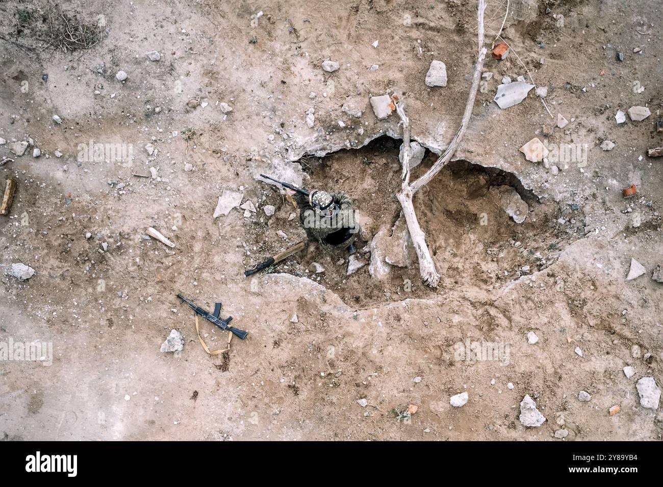 aerial view of two soldiers in military uniforms sitting in trench with ...