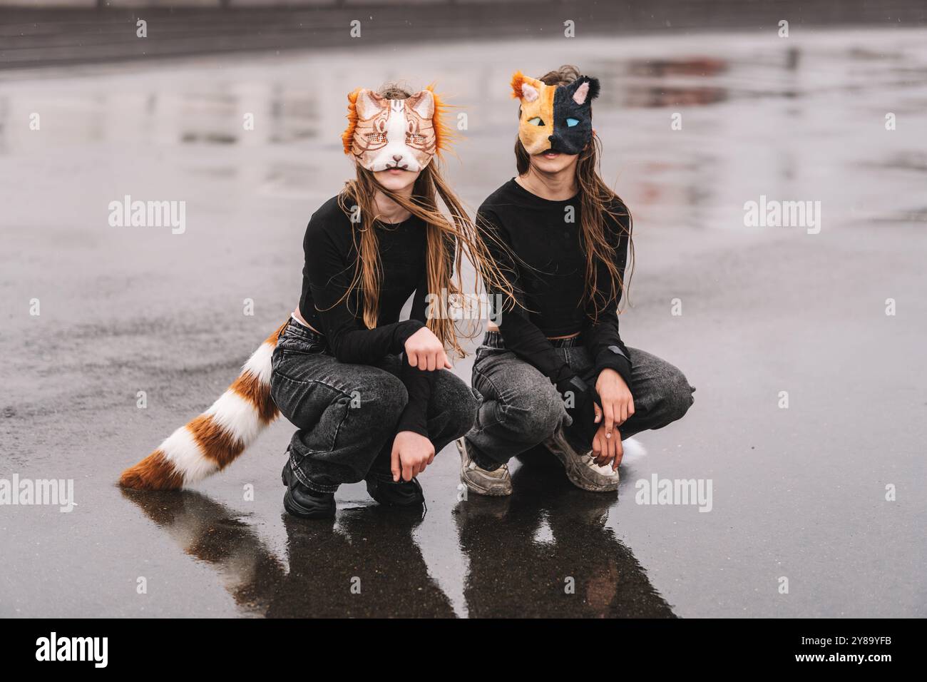 Teenage girls with cat mask and gloves doing Quadrobics. A girls in a ...