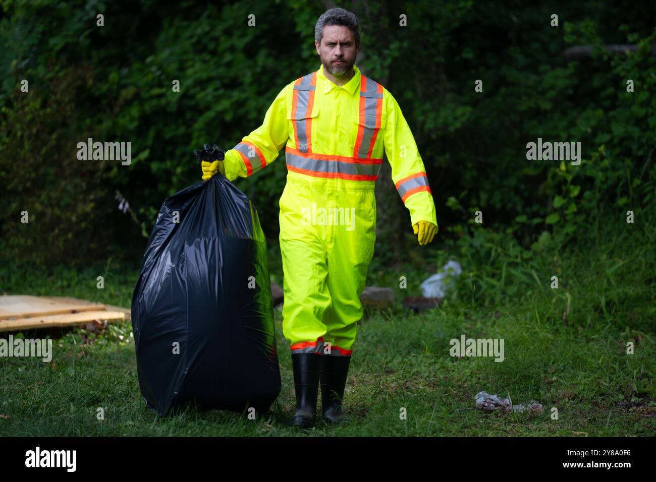 Man in uniform picking up garbage plastic for cleaning. Man collecting ...