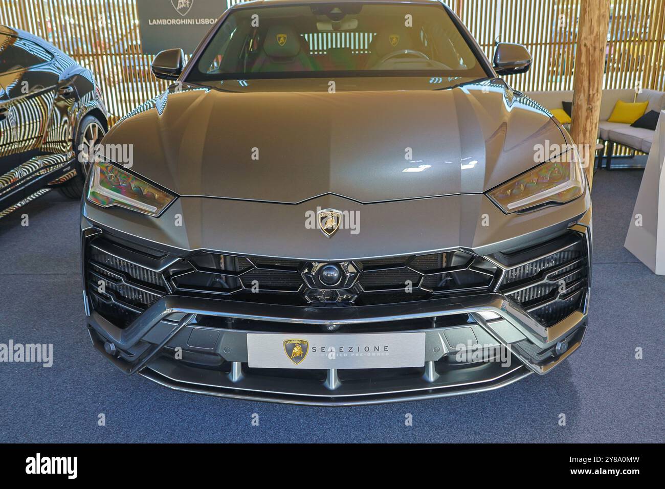 Gray lamborghini urus is parked in a modern car dealership, showcasing ...