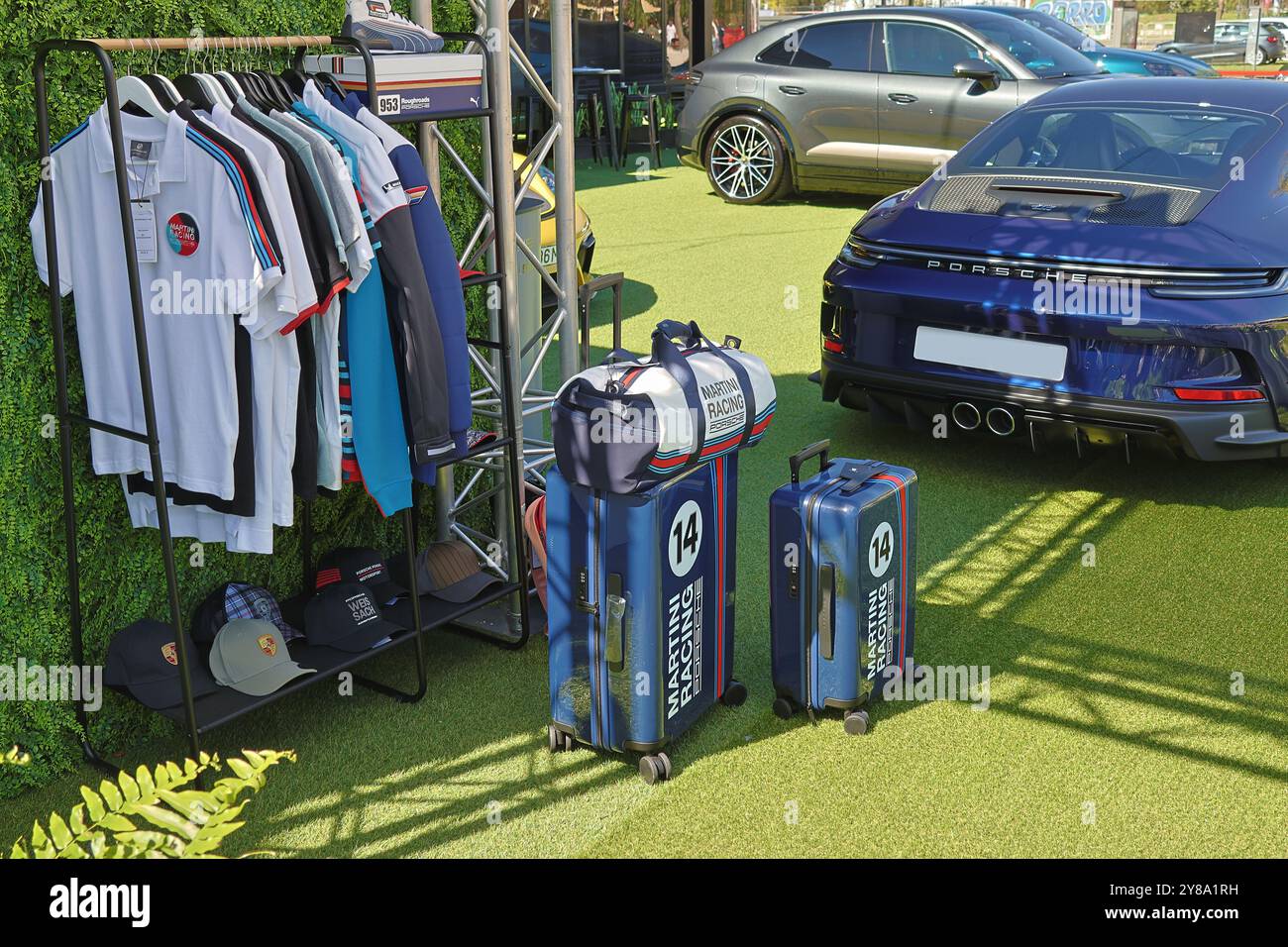 Porsche dealership displaying branded clothes and luggage with cars in ...